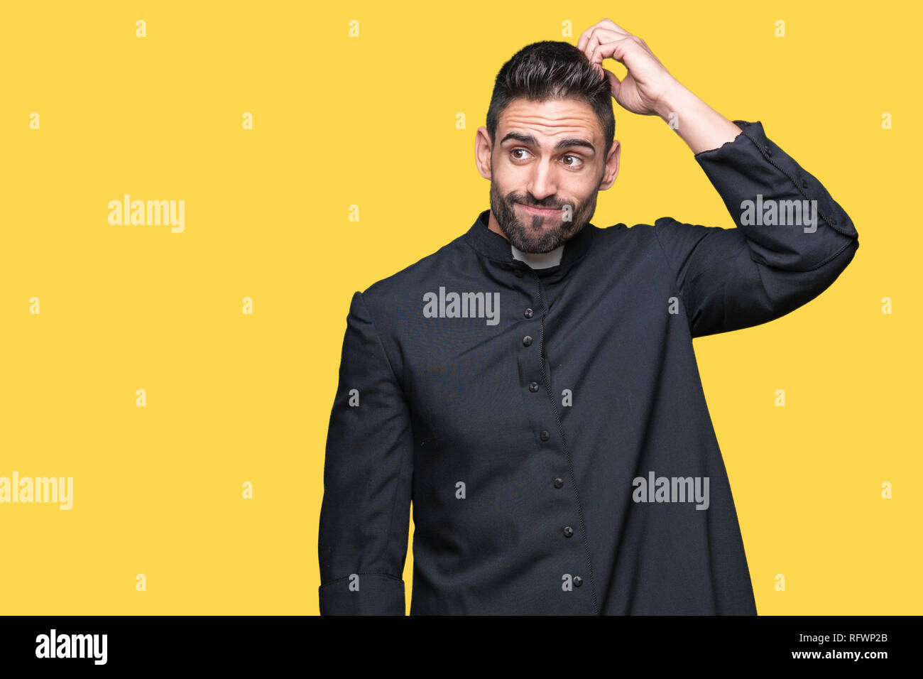 Young Christian priest over isolated background confuse and wonder ...