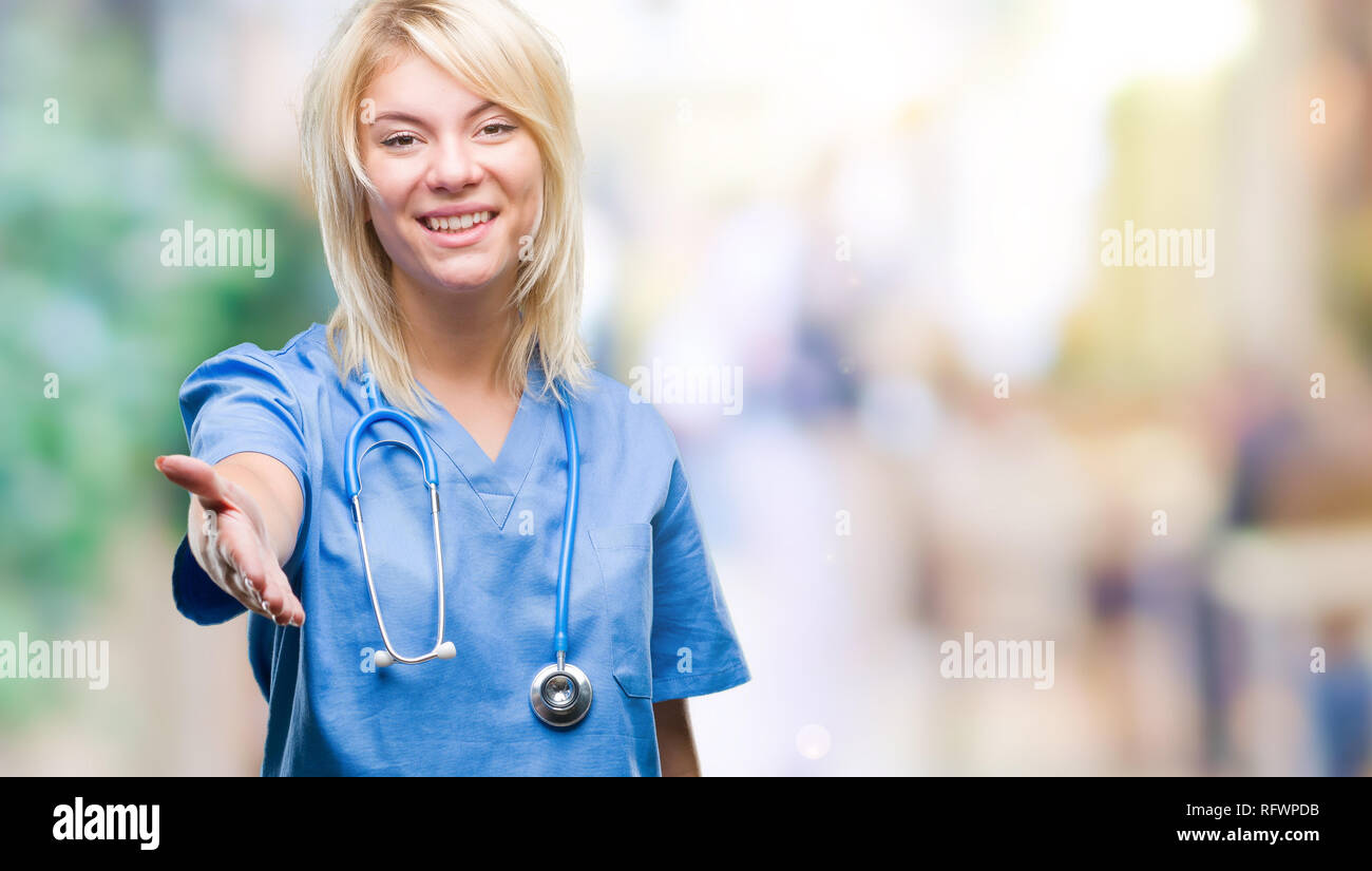 Young beautiful blonde doctor woman wearing medical uniform over ...