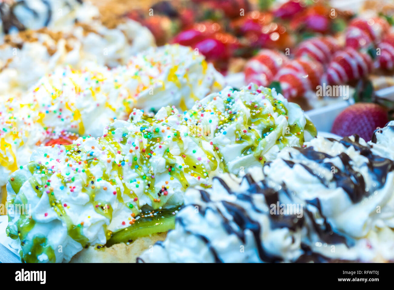 colorful cake sweet dessert with whipped cream at a street food market ...