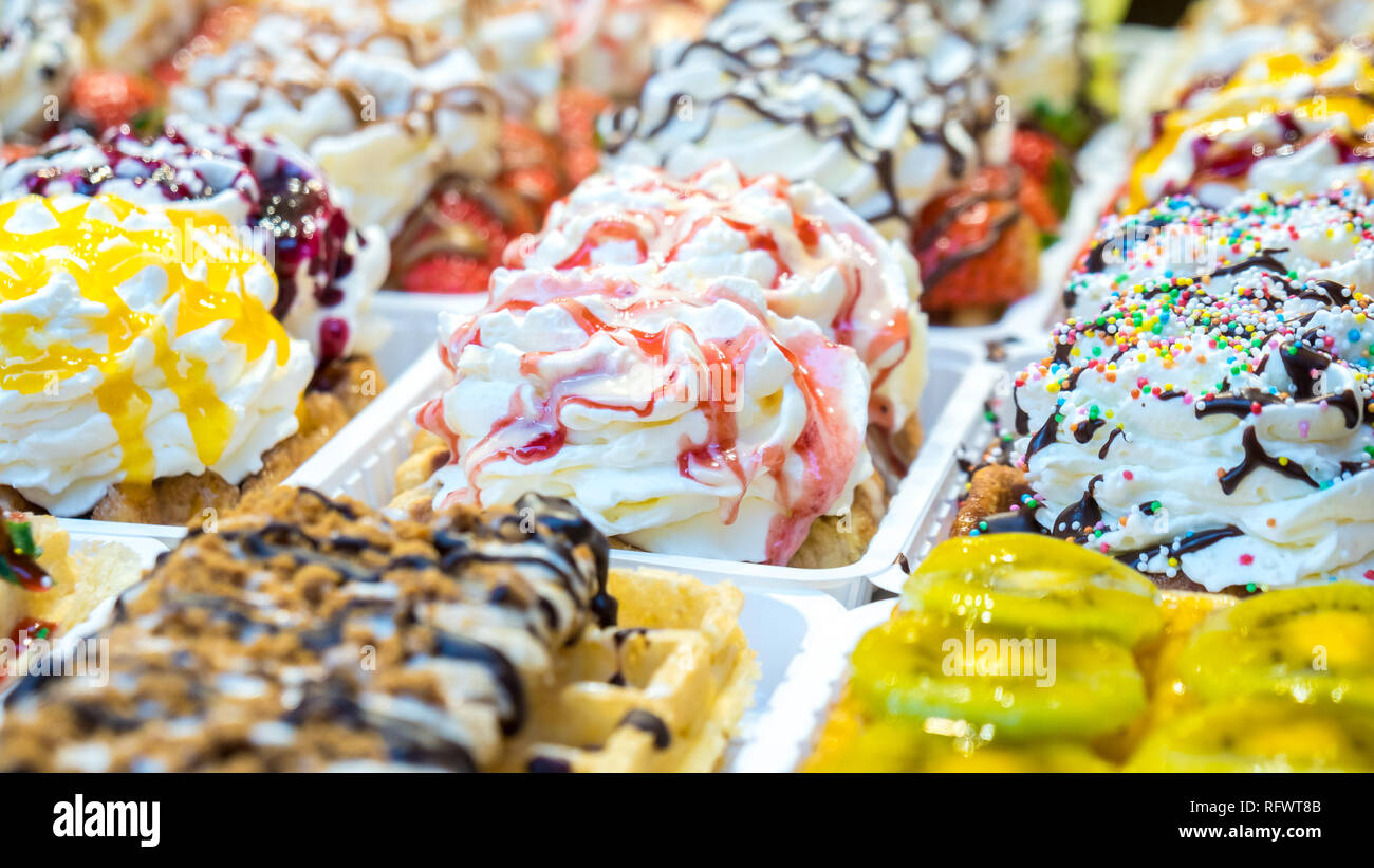 colorful cake sweet dessert with whipped cream at a street food market ...