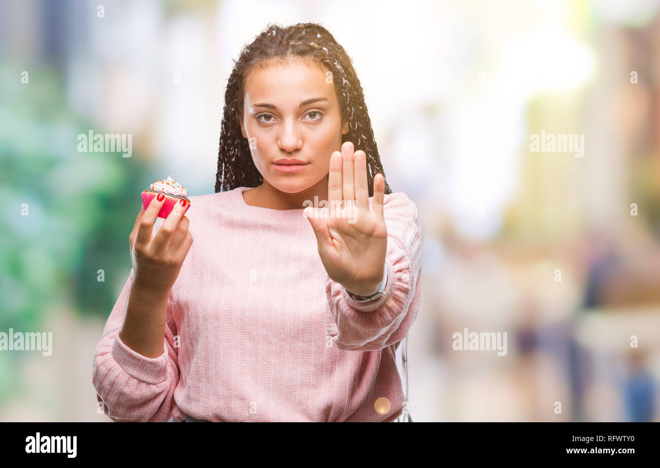Young african american girl eating cupcake over isolated background ...