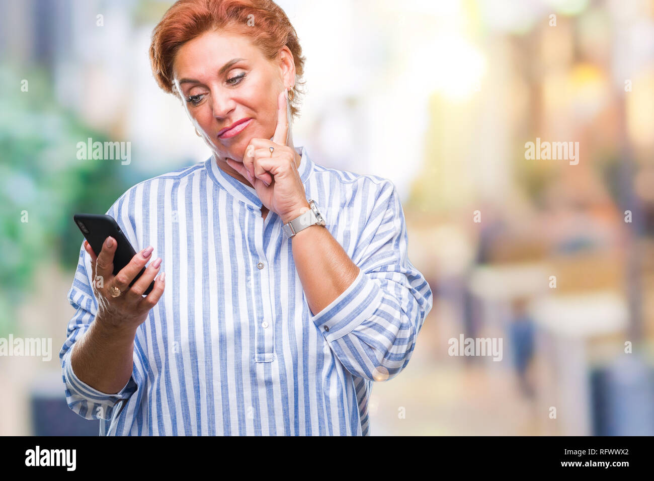 Atrractive senior caucasian redhead woman texting using smartphone over ...