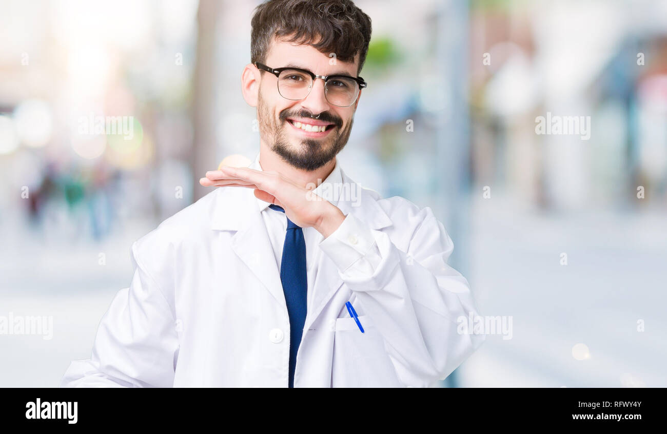 Young professional scientist man wearing white coat over isolated ...