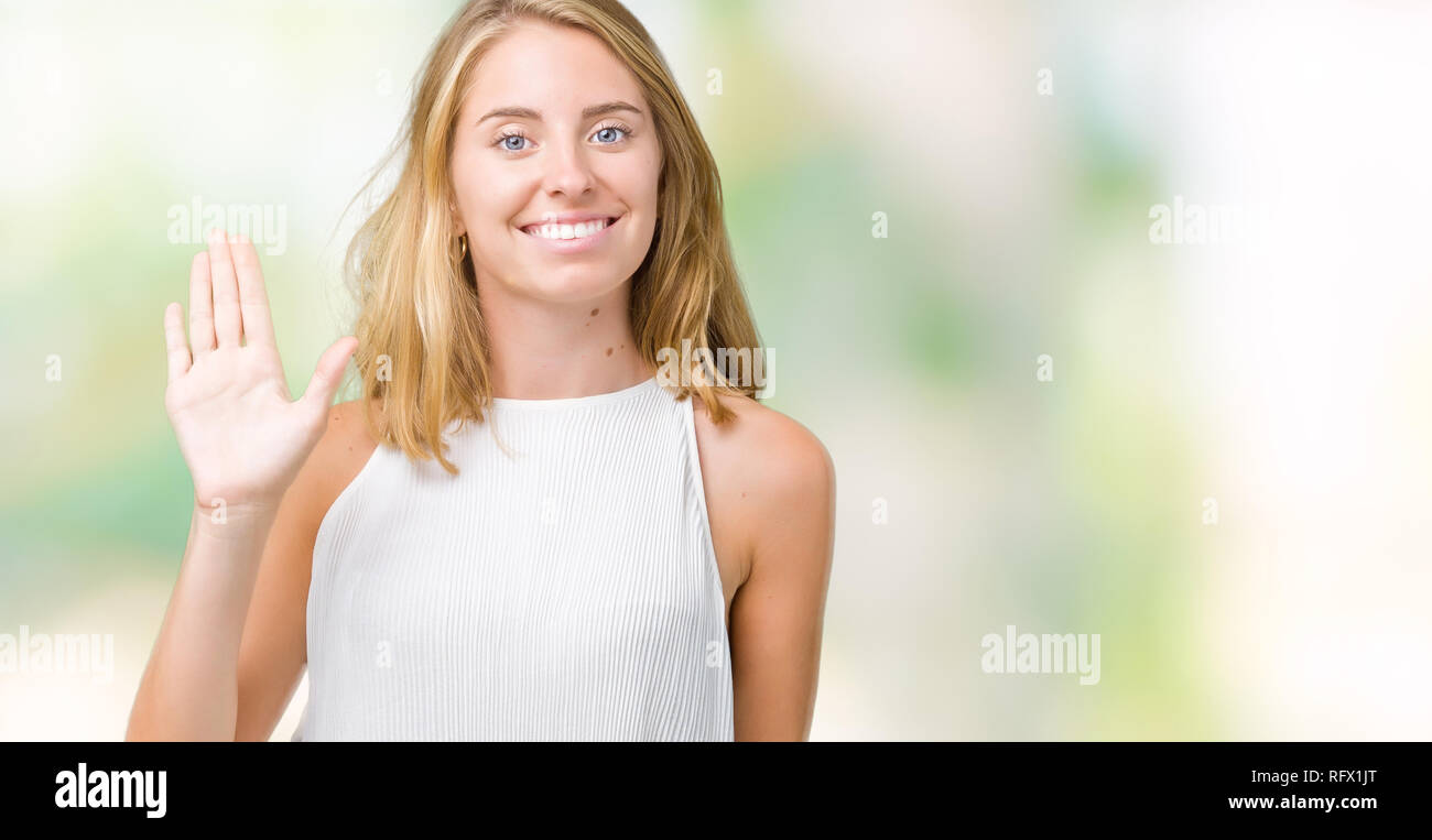 Beautiful young elegant woman over isolated background Waiving saying ...