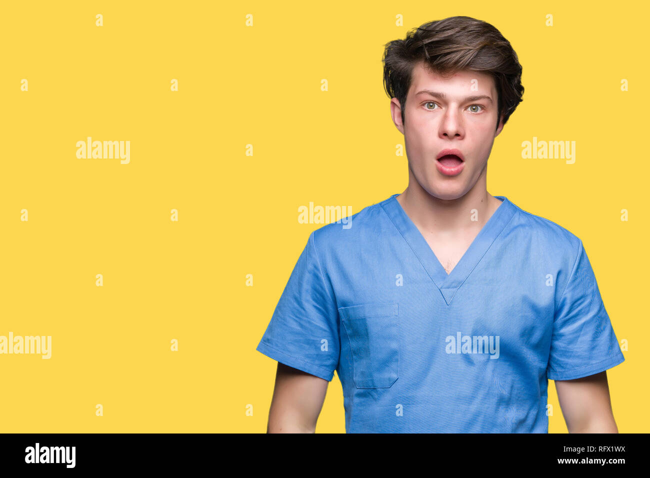 Young doctor wearing medical uniform over isolated background afraid ...