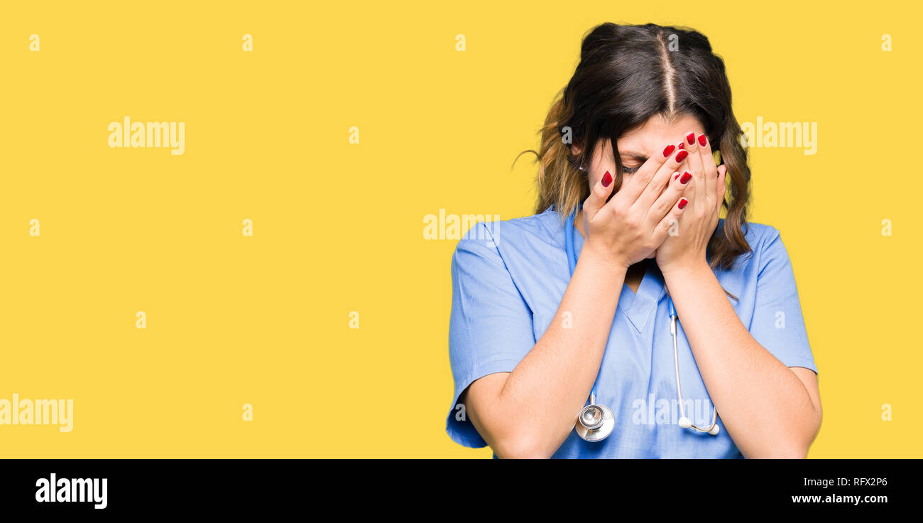 Young adult doctor woman wearing medical uniform with sad expression ...