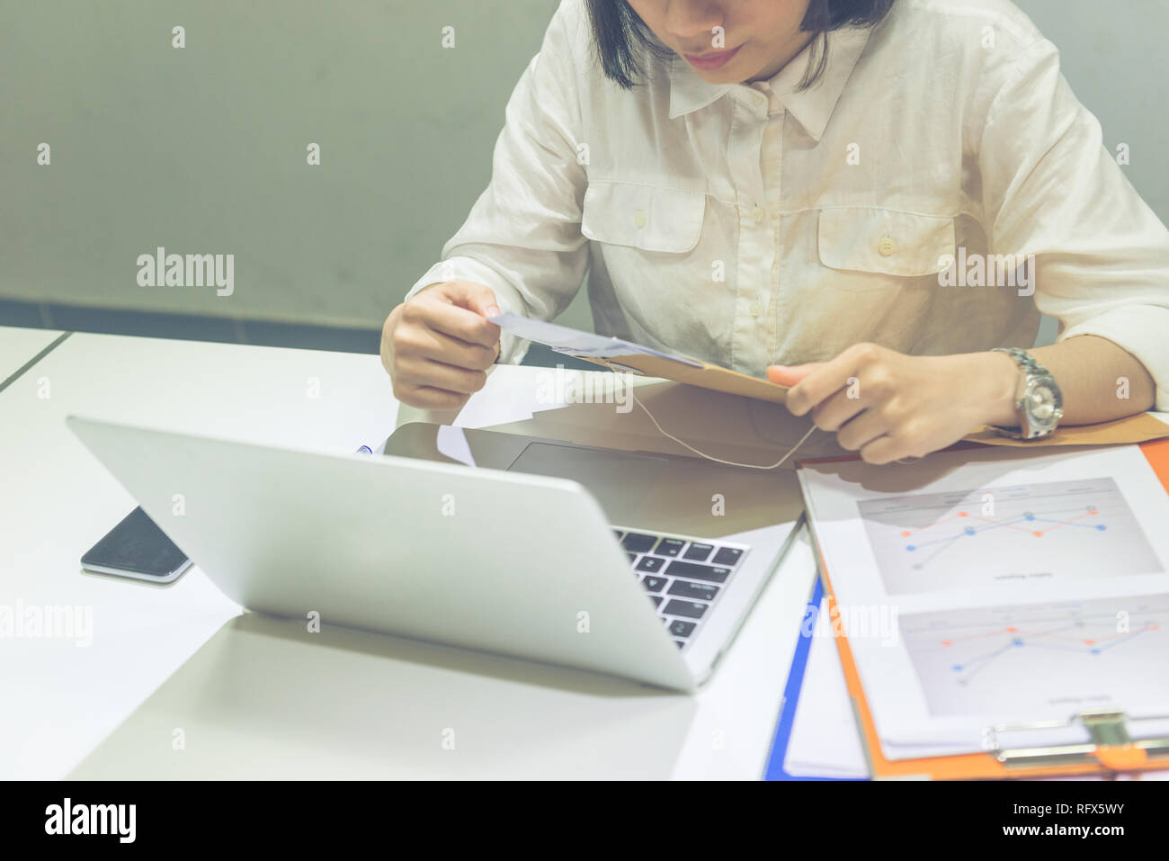 Businesswoman hand open a letter from brown envelope Stock Photo - Alamy