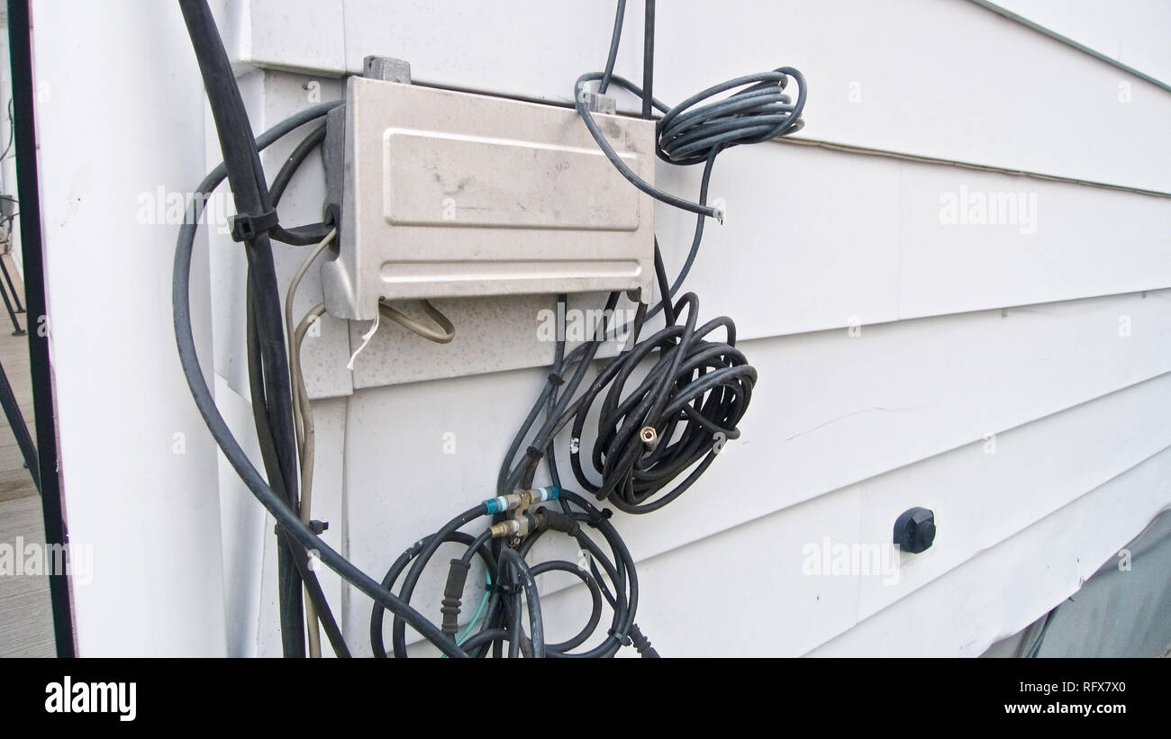 A telecommunications box installed and attached to the siding of a ...
