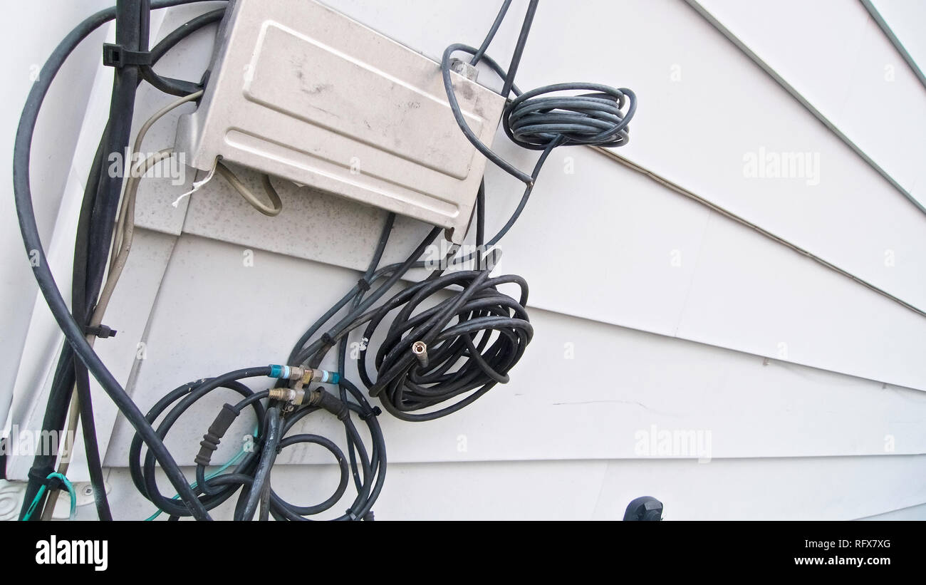 A telecommunications box installed and attached to the siding of a ...