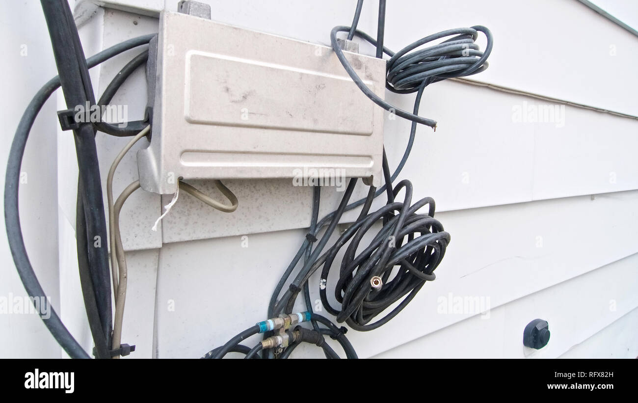 A telecommunications box installed and attached to the siding of a ...