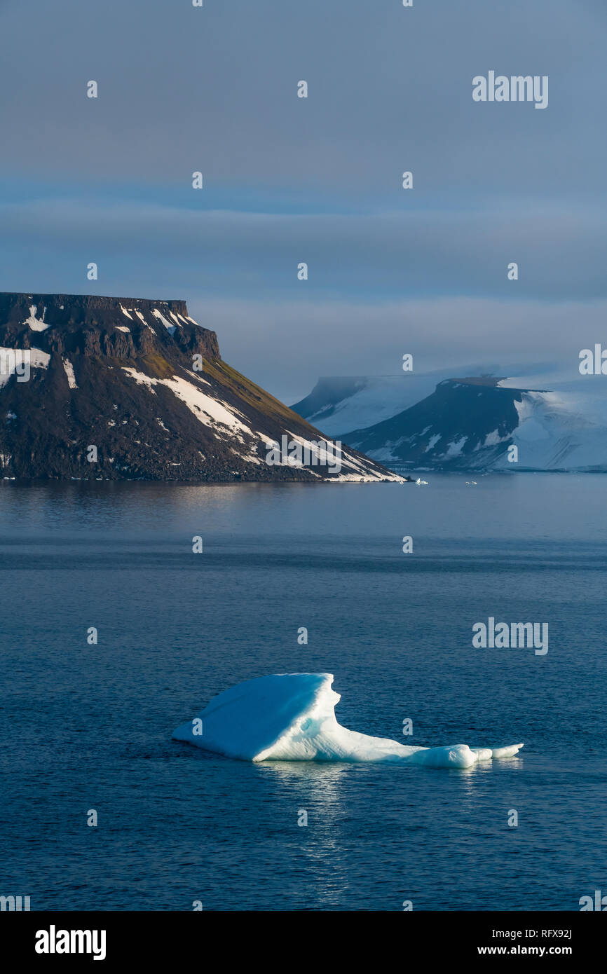 Iceberg floating in front of flat table mountains covered with ice ...