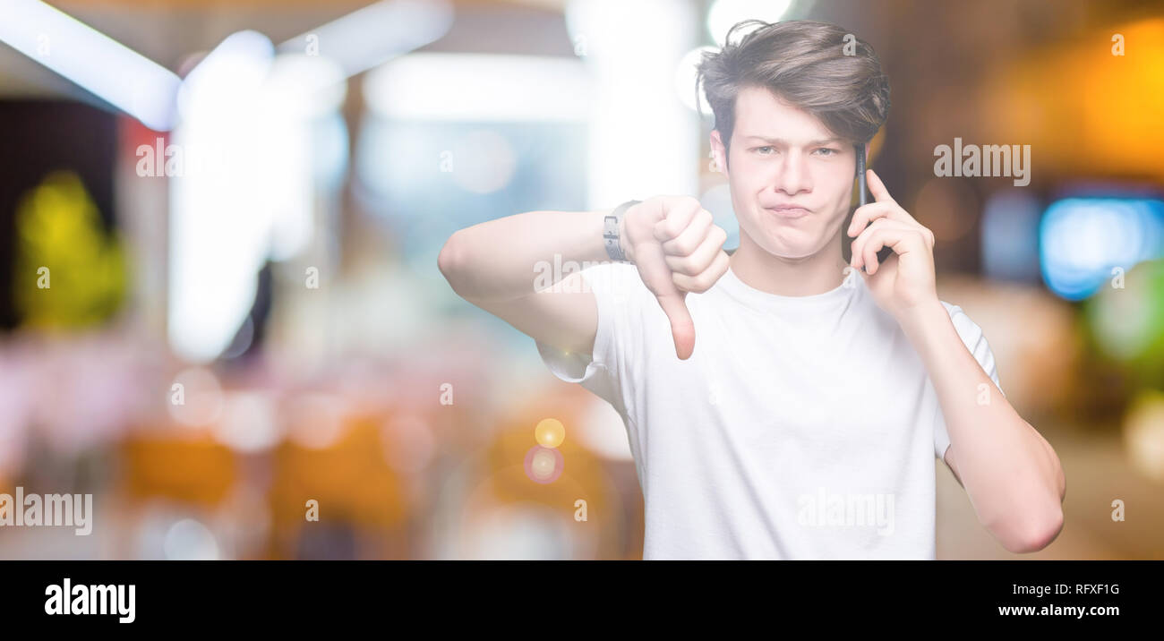 Young man talking on smartphone over isolated background with angry ...