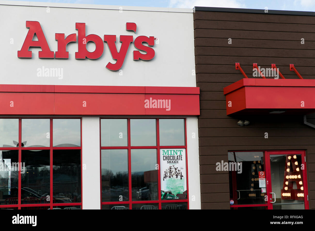 A logo sign outside of a Arby's fast-food restaurant location in ...