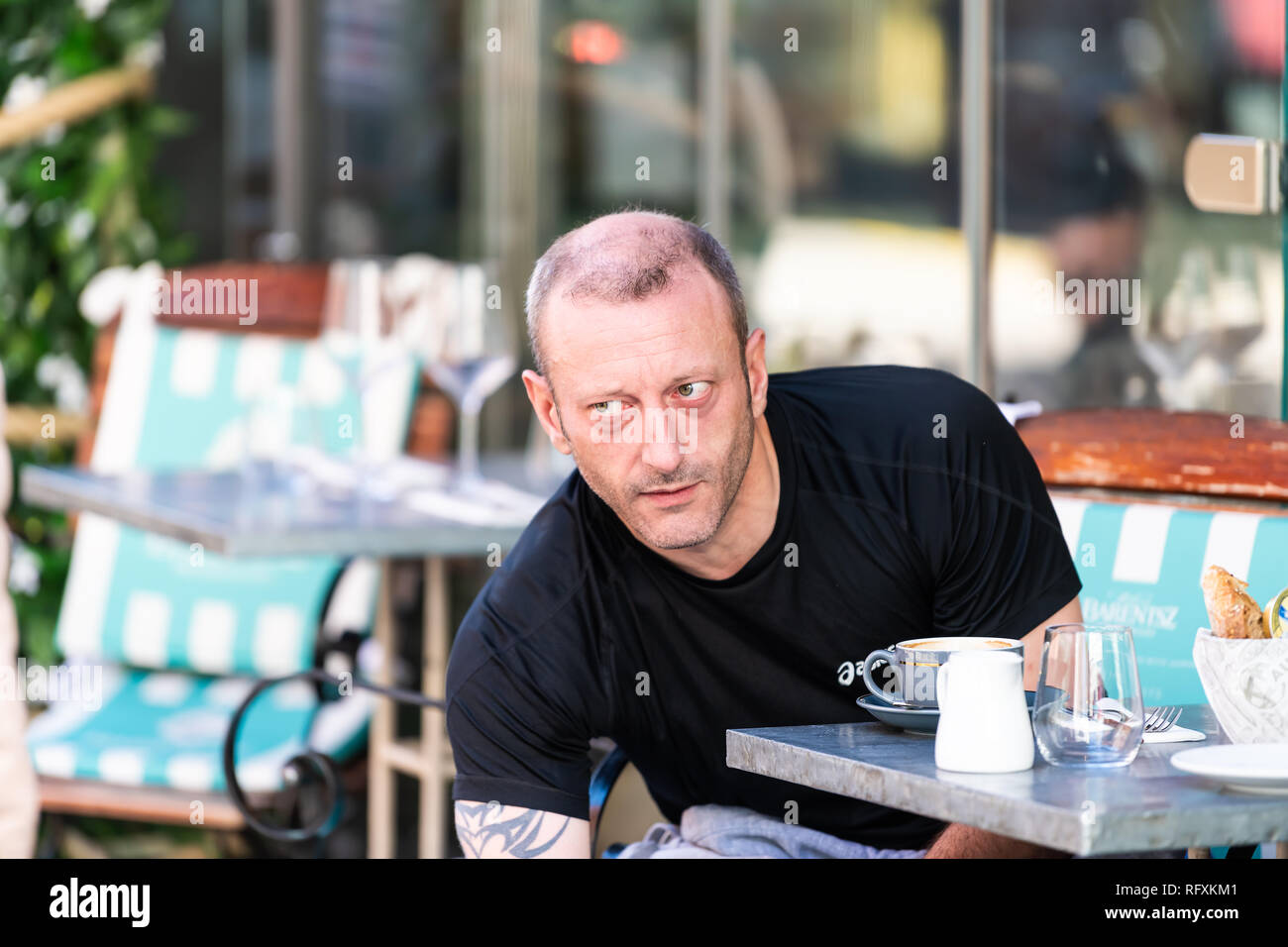 London, UK - September 13, 2018: Man sitting at cafe table with coffee ...