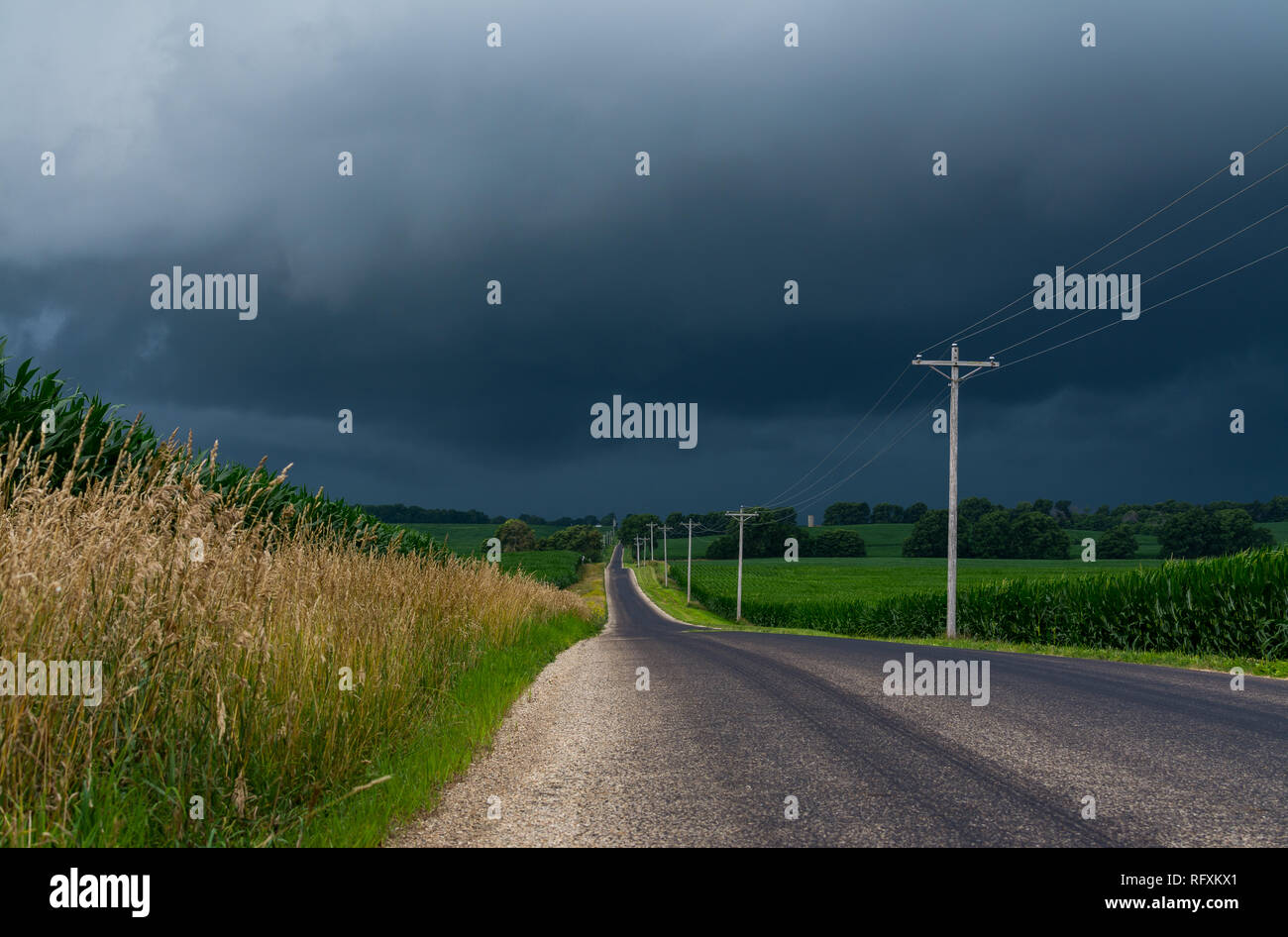 Incoming thunderstorm clouds with road going through rural countryside ...