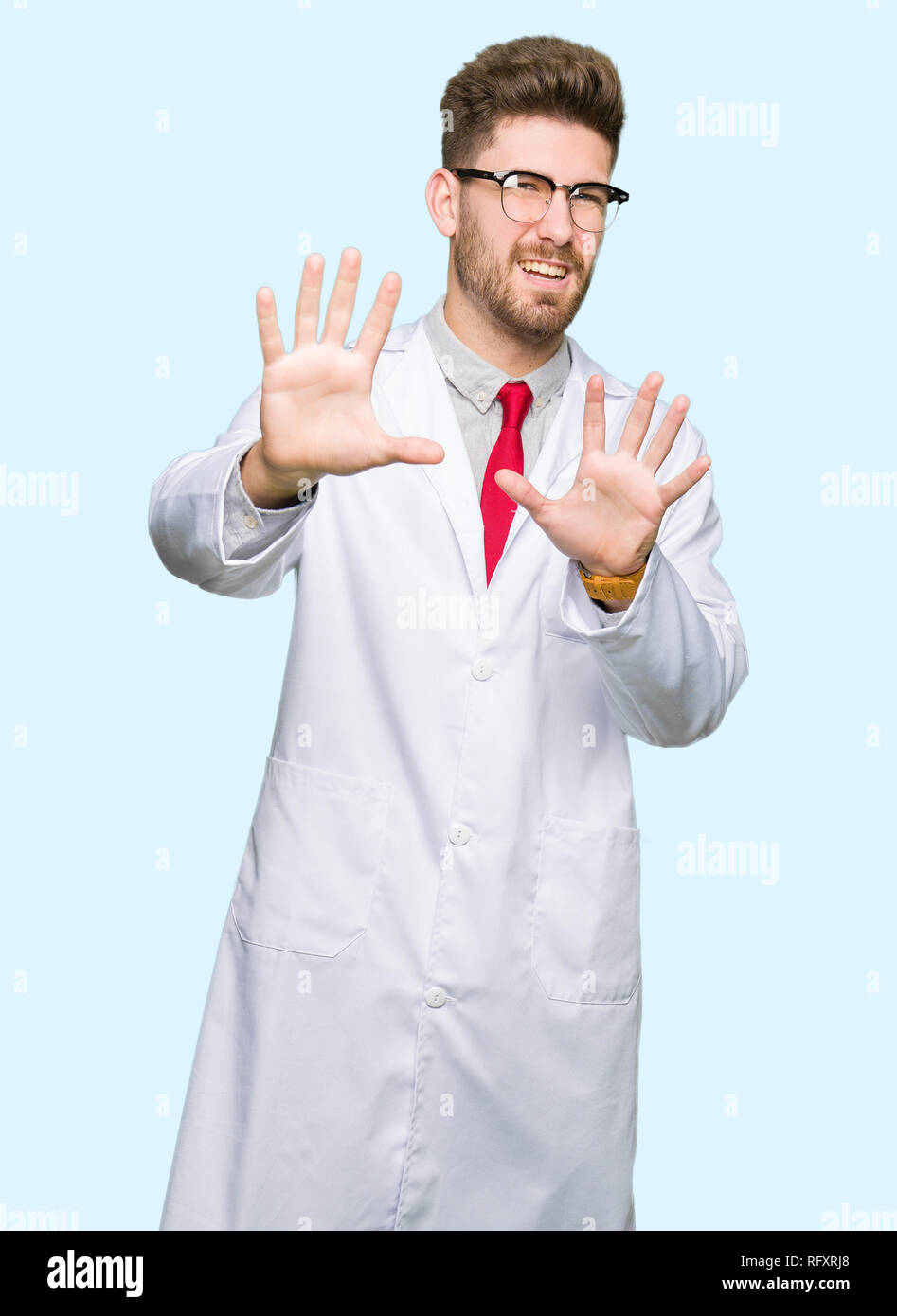 Young handsome scientist man wearing glasses afraid and terrified with ...