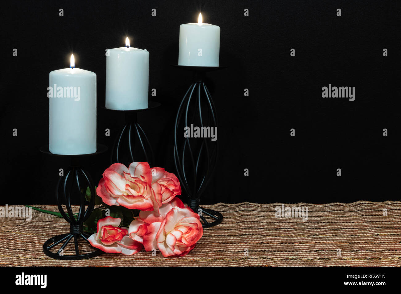 Beautiful orange and white roses, white candle perched on black candle ...