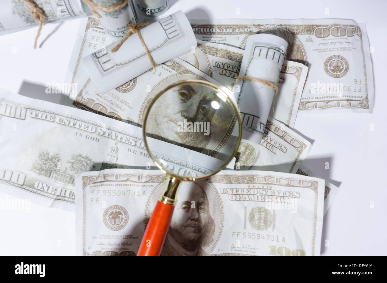 Magnifying glass with dollar bills Stock Photo - Alamy