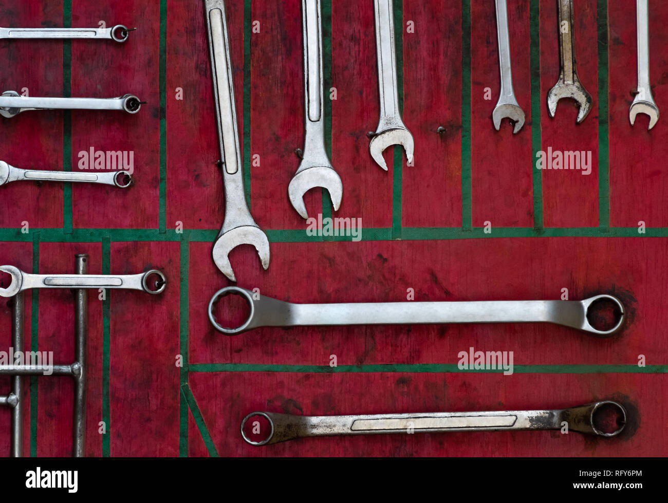 Metallic tools on red wall Stock Photo - Alamy