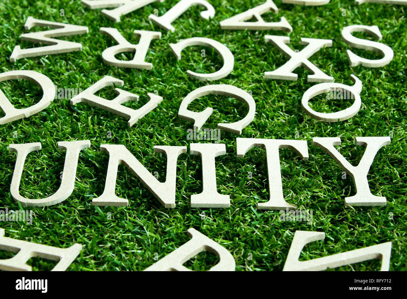 Wording unity on artificial green grass background with english ...