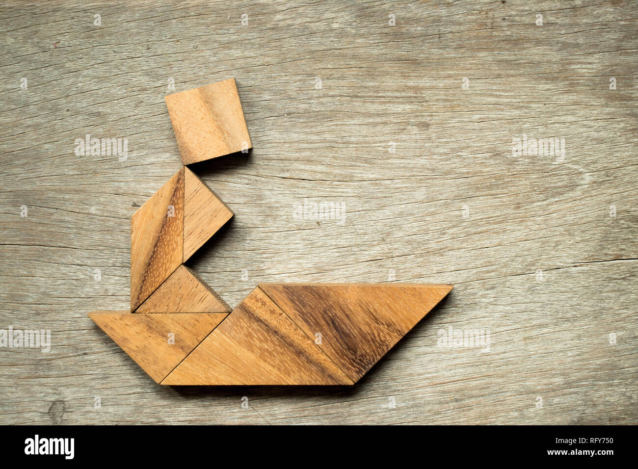 Tangram puzzle in man sail the boat shape on wooden background Stock ...