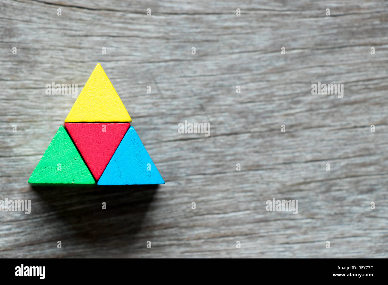 Mulit color toy block compound as triangle shape on wood background ...