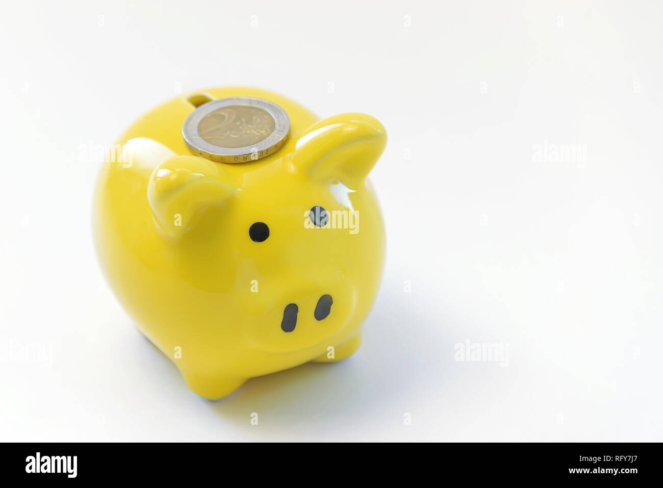 yellow pig piggy Bank with one coin on white background Stock Photo - Alamy