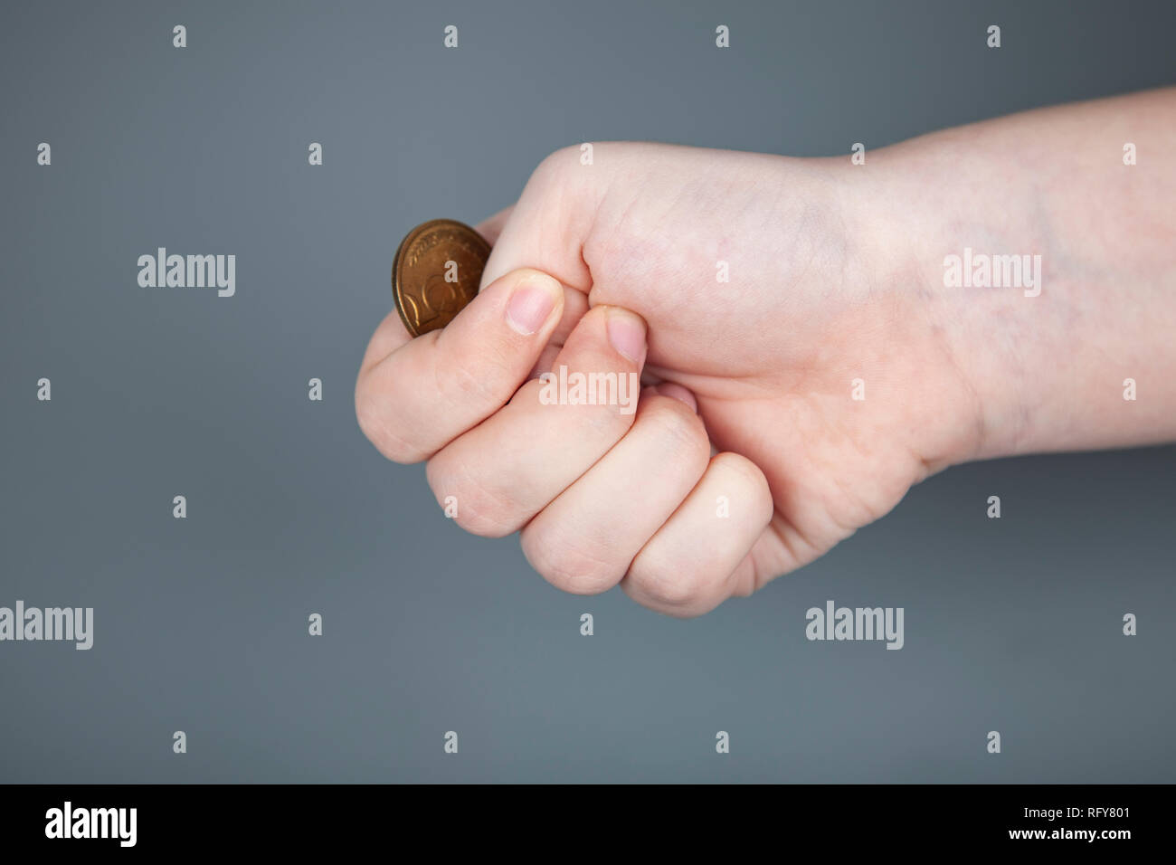 Hand with a coin on a gray background Stock Photo - Alamy