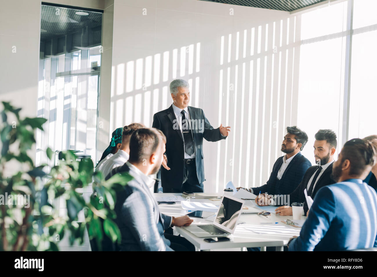 Multiracial male business executives discuss project sitting at ...