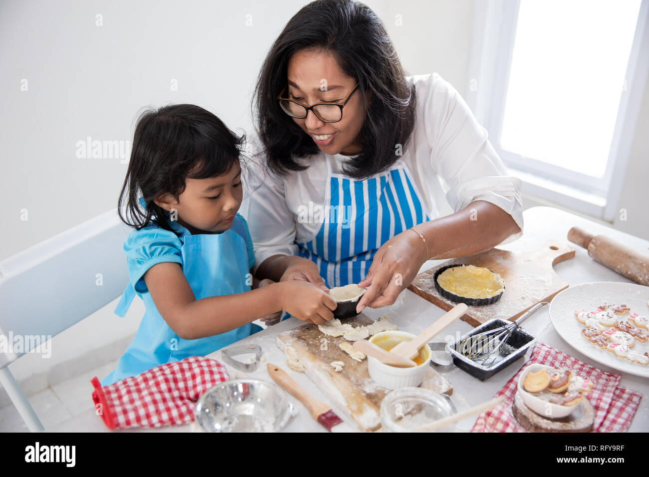 mother and kid learning to make some dough Stock Photo - Alamy