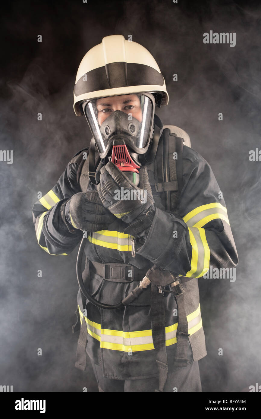 Firefighter wearing protective suit, helmet and mask Stock Photo - Alamy