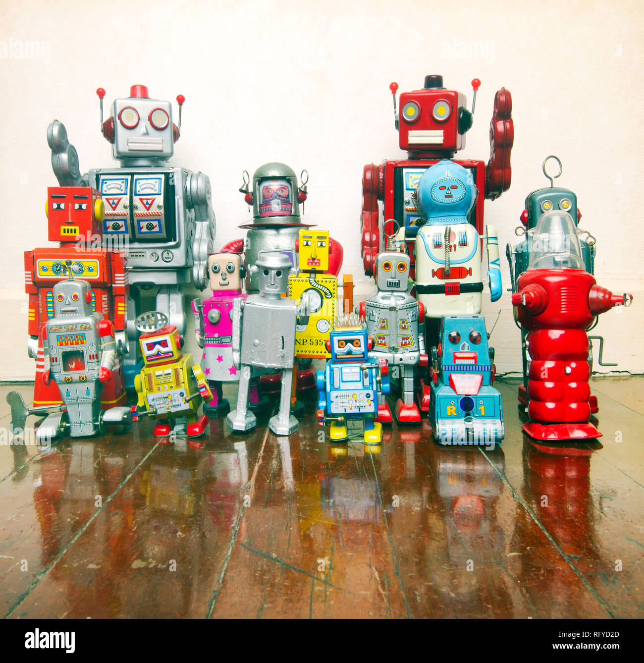 a large group of retro tin robot toys on a old wooden floor with ...