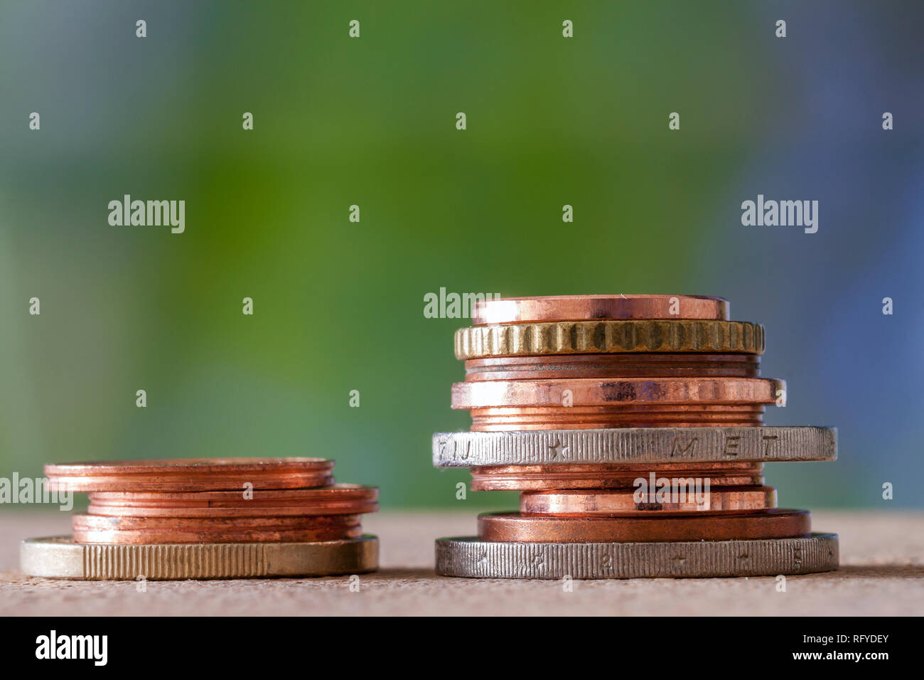 Two piles of coins different size and color stacked on each other on ...