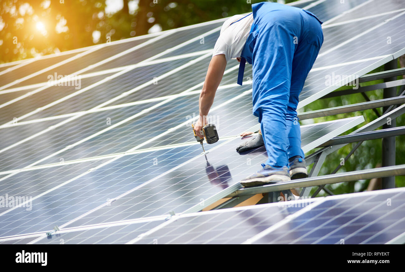 Construction worker connecting photo voltaic panel to solar system ...