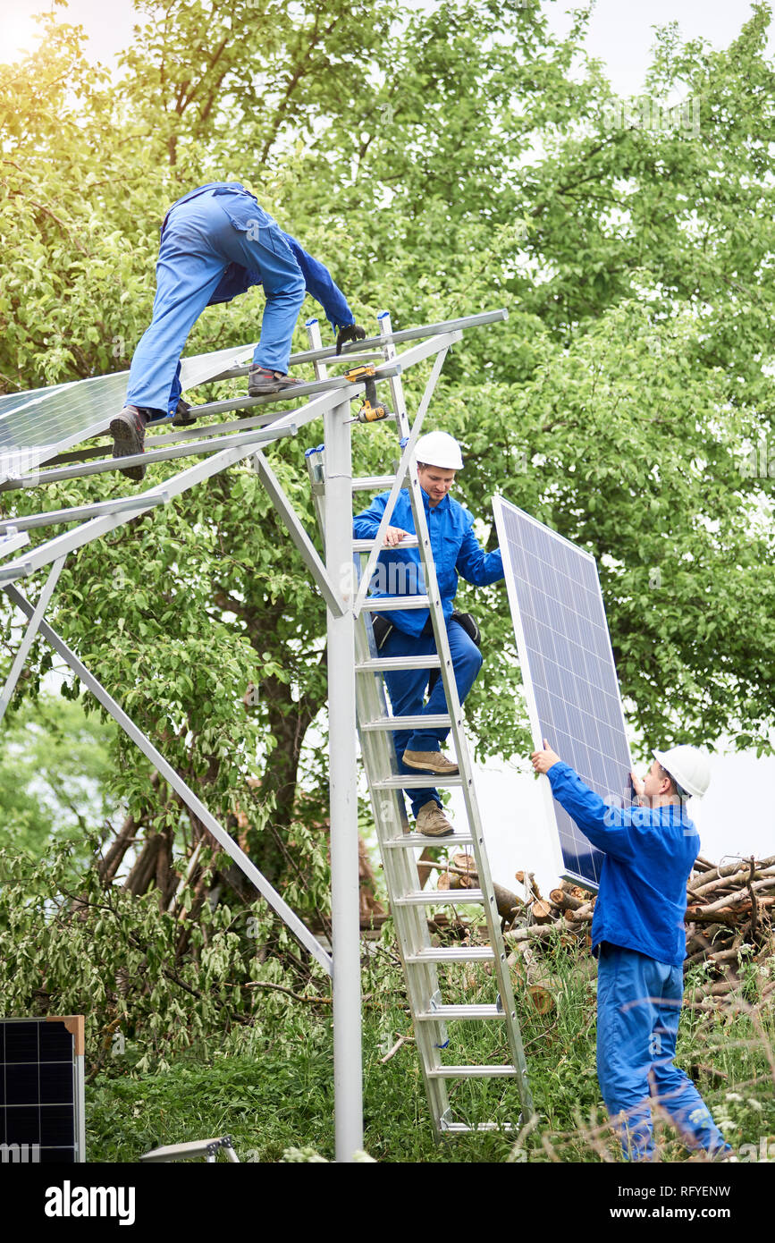 Installing of stand-alone solar photo voltaic panel system. Workers in ...