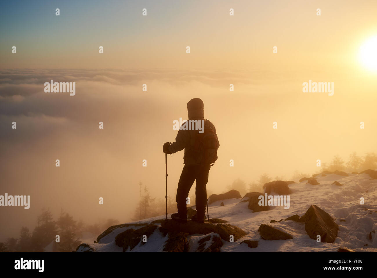 Back view of silhouette tourist hiker with backpack and hiking sticks ...