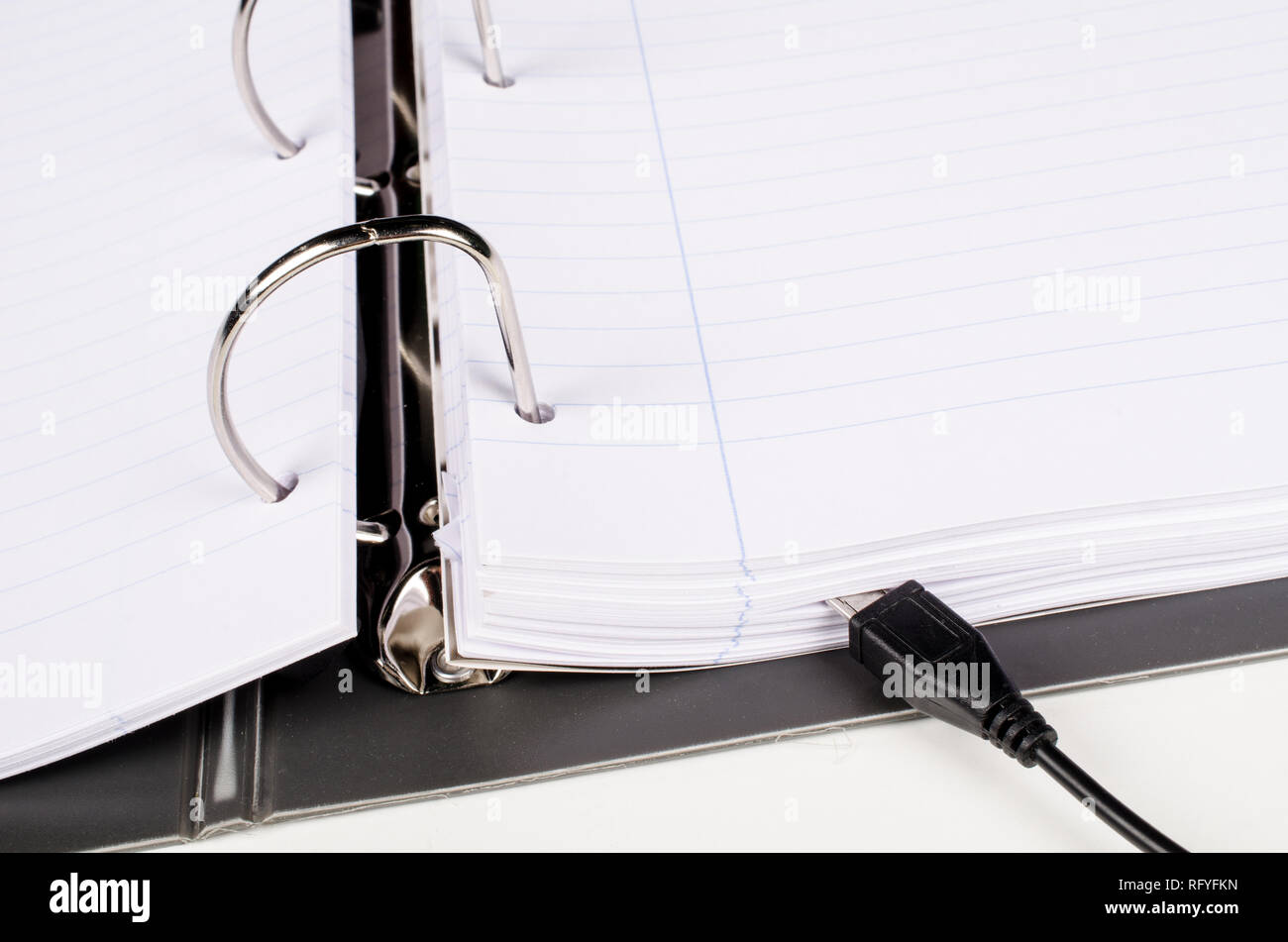 Paper notebook connected to a usb charger, a concept of analog vs ...