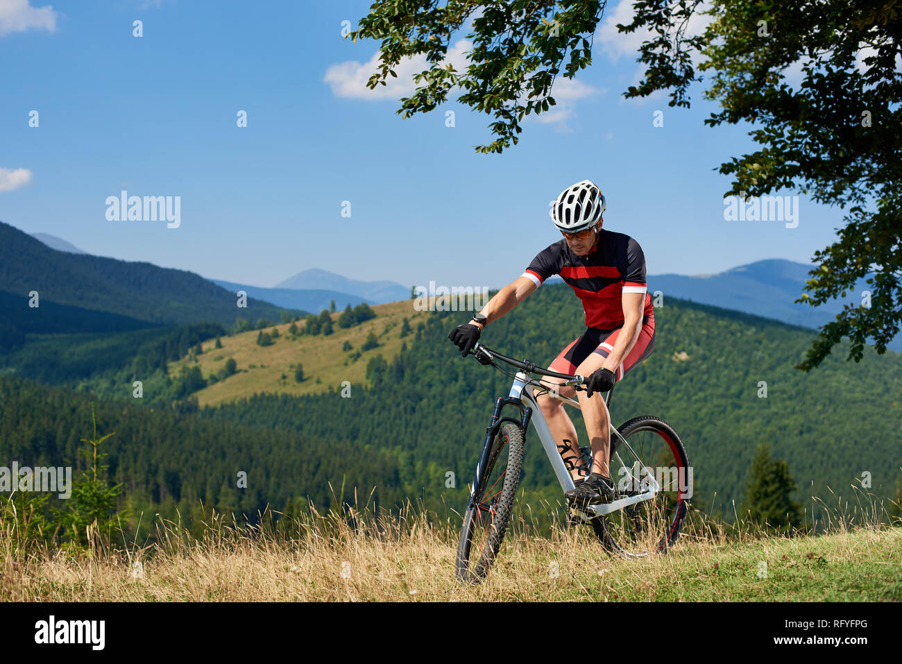 Young athletic tourist in professional sportswear cycling a bike in ...
