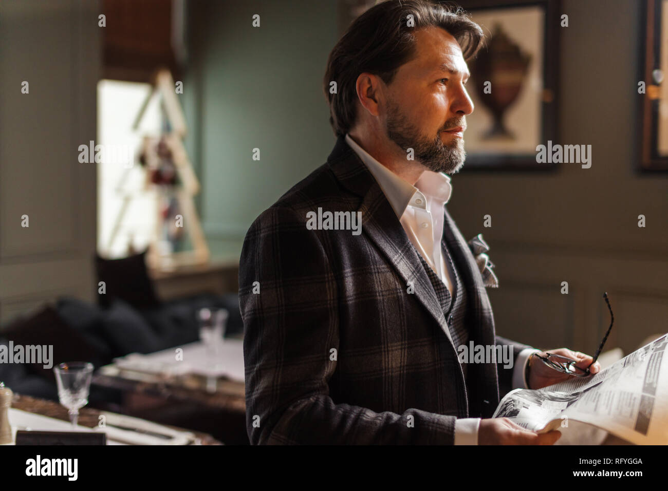 Well-dressed business man reading newspaper in indoor restaurant Stock ...