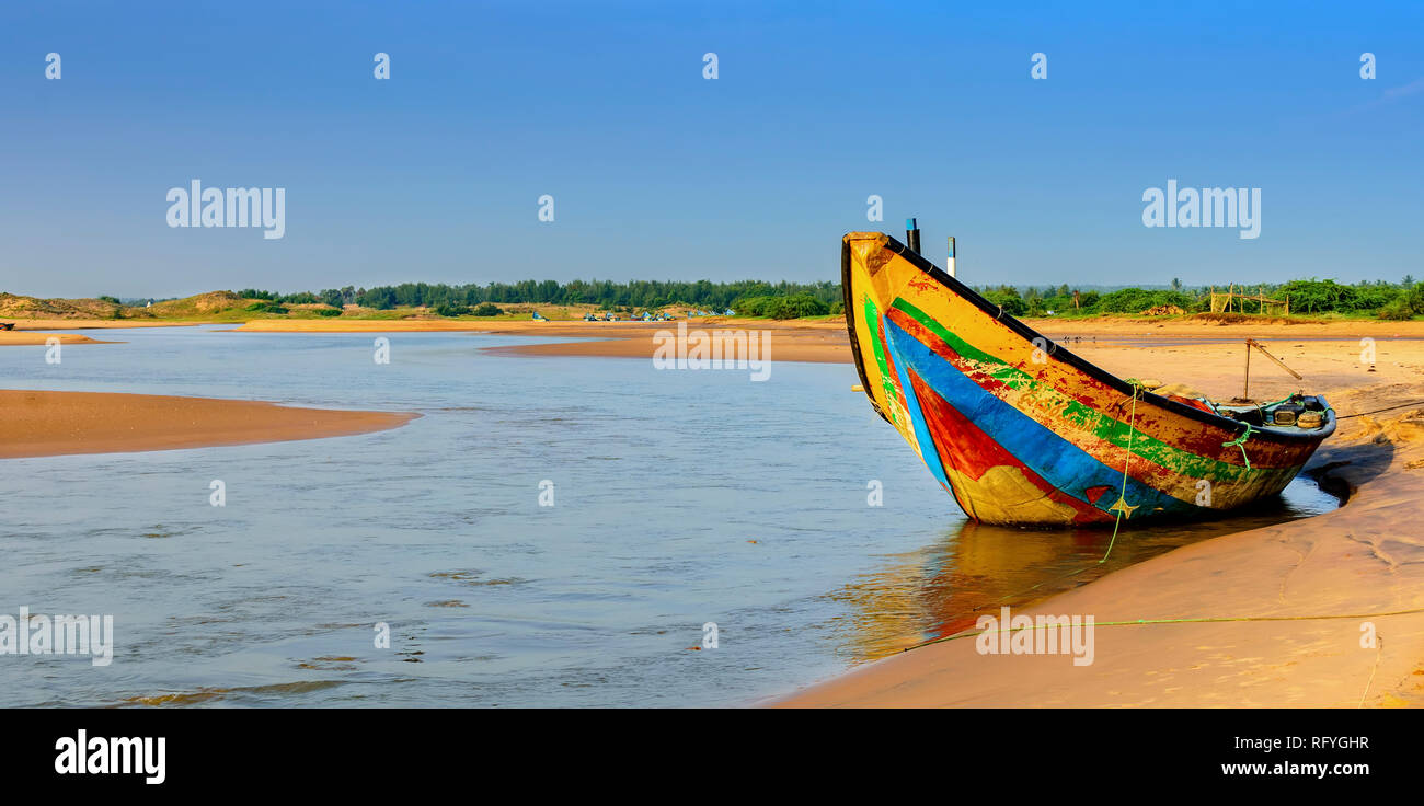 A traditional colourful fishing boat anchored at the confluence of ...