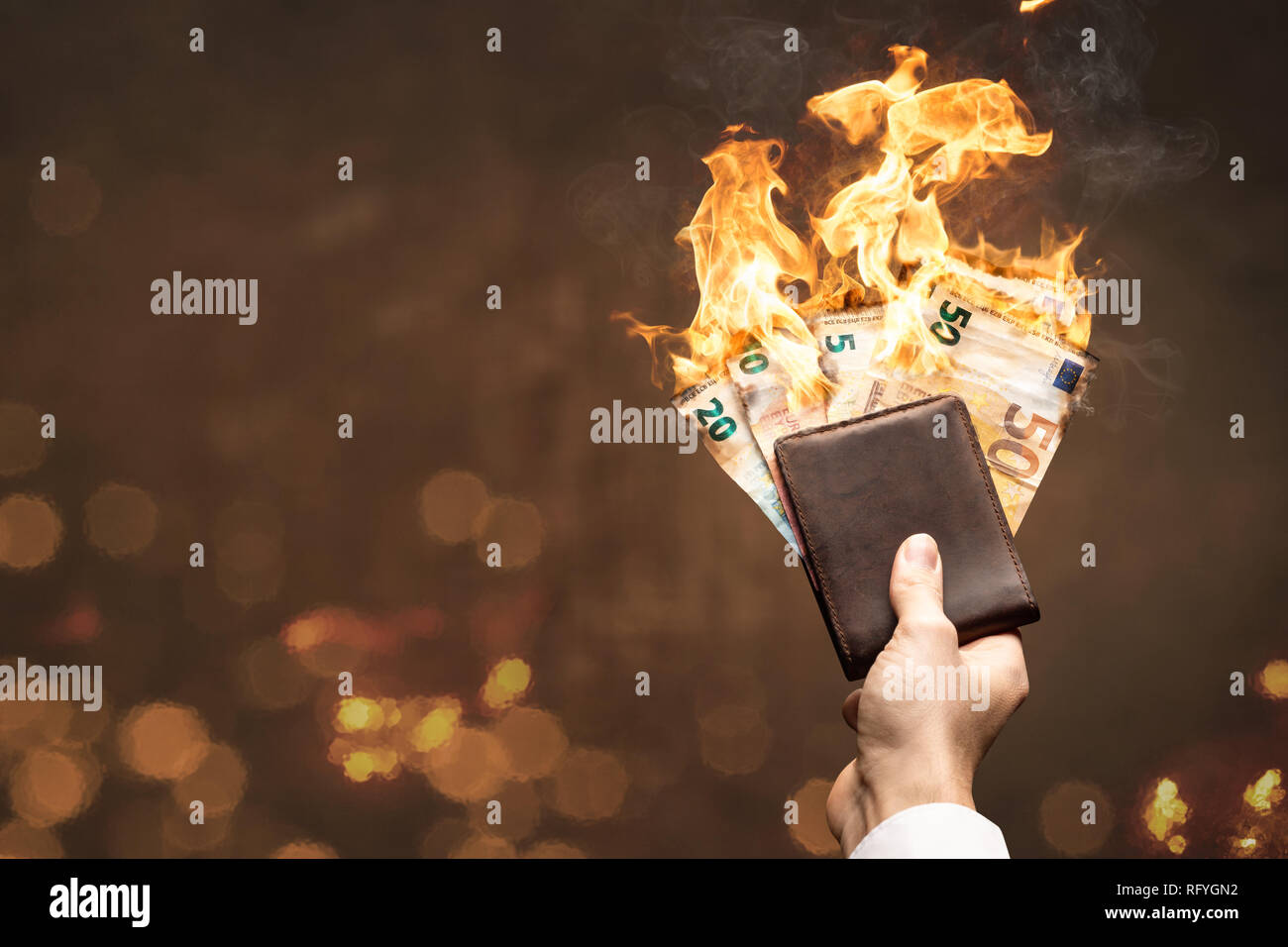 Burning Euro bills in a hand-held wallet Stock Photo - Alamy