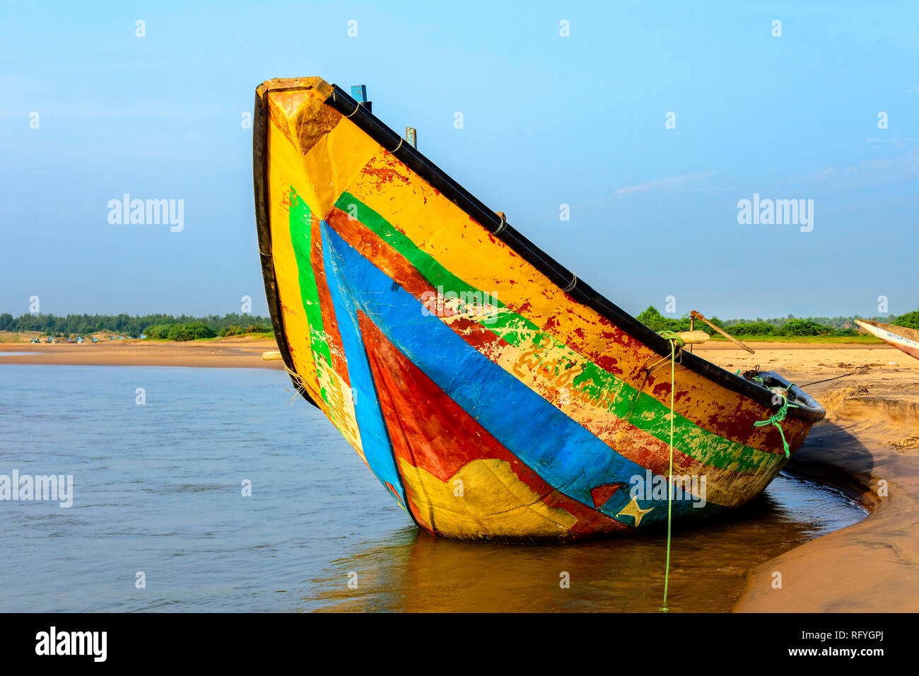 A traditional colourful fishing boat anchored at the confluence of ...