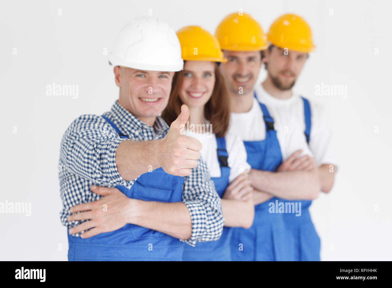 Group portrait of construction workers standing in a row and smiling ...