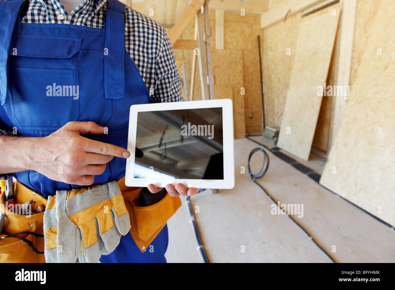 Construction worker pointing at digital tablet at construction site ...