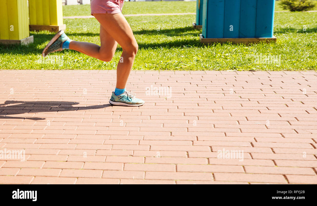 legs of girl running in a sports competition on sunny summer morning ...