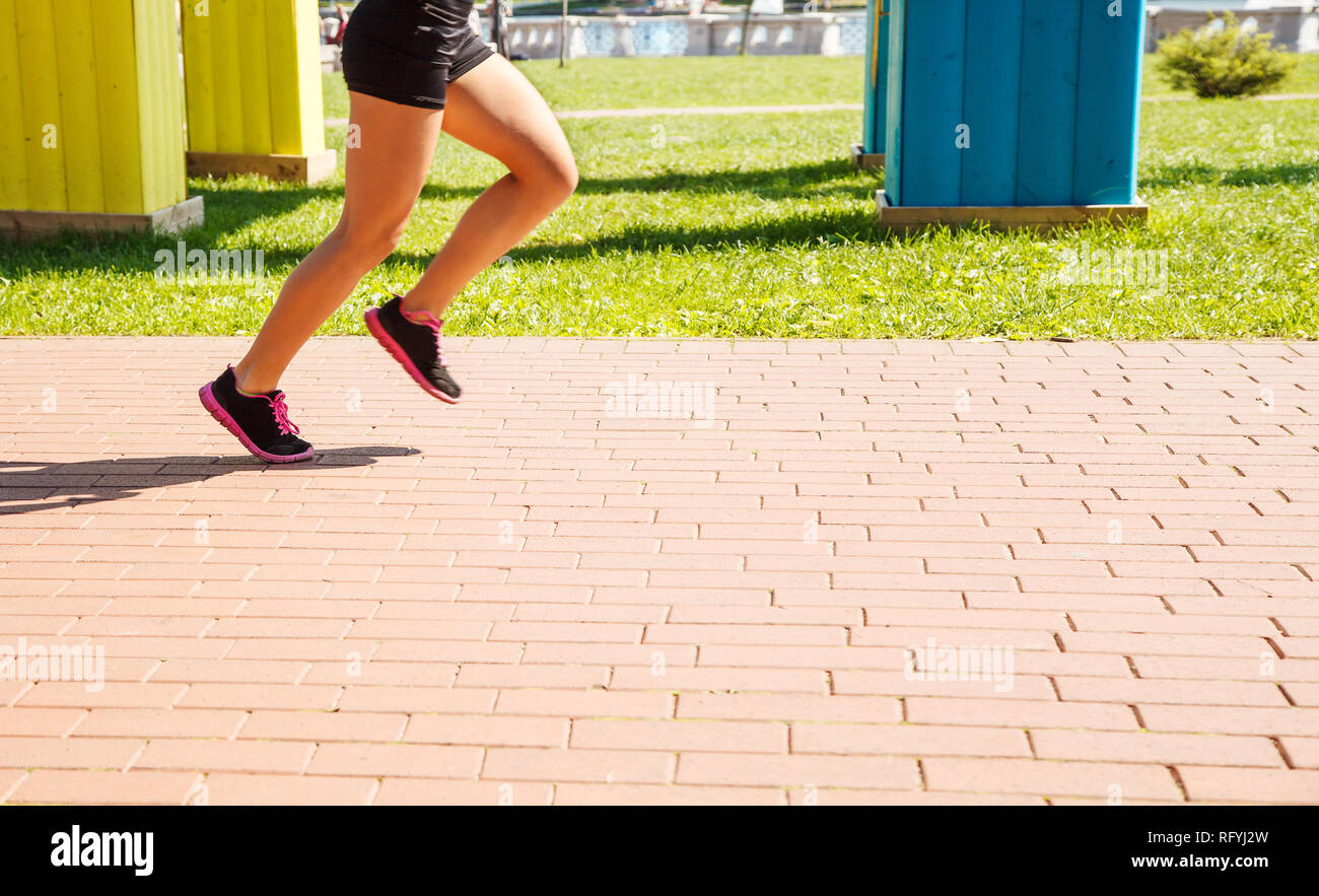 legs of girl running in a sports competition on sunny summer morning ...