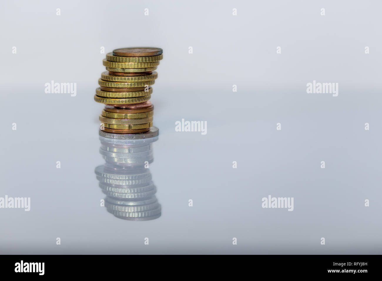 Coin mountain isolated reflected in a plastic surface Stock Photo - Alamy