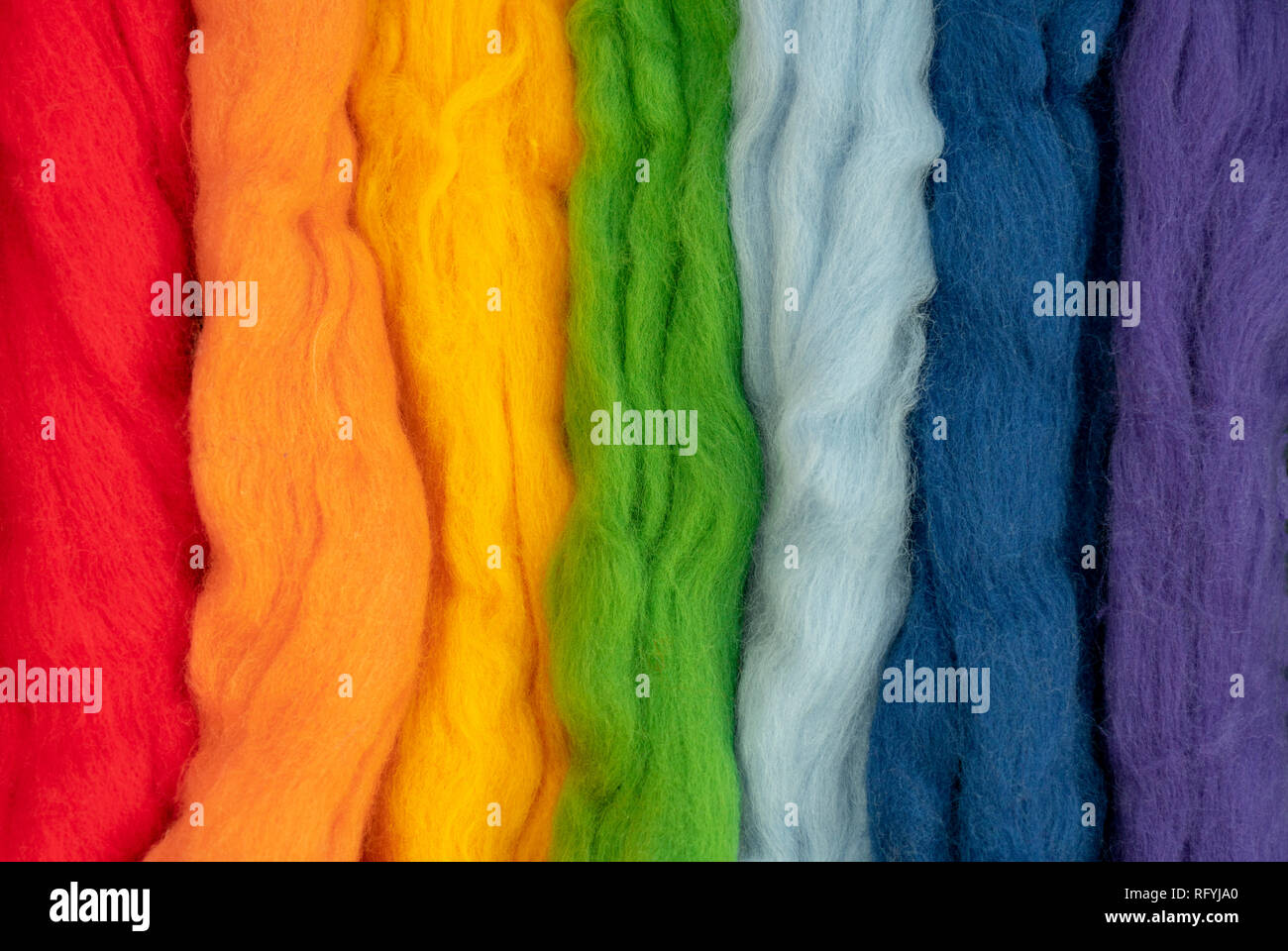 Tufts of wool of different colors parallel to each other form a rainbow ...