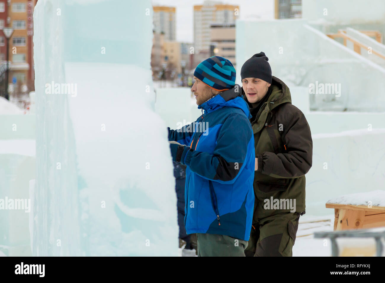A worker approaches an artist who draws on an ice block Stock Photo - Alamy