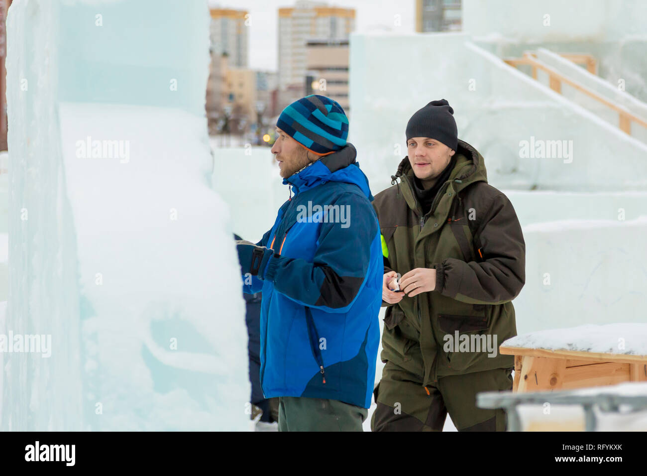 A worker approaches an artist who draws on an ice block Stock Photo - Alamy